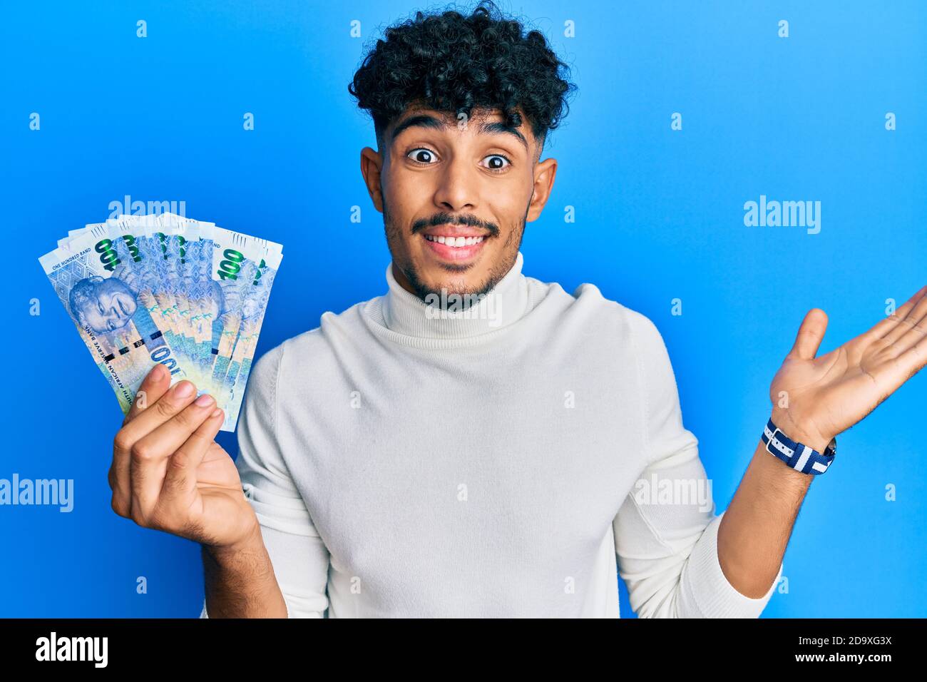 Young arab handsome man holding south african 100 rand banknotes ...