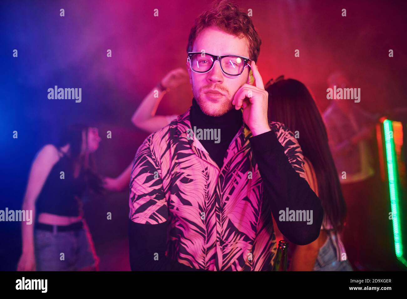 Young people is having fun in night club with colorful laser lights ...