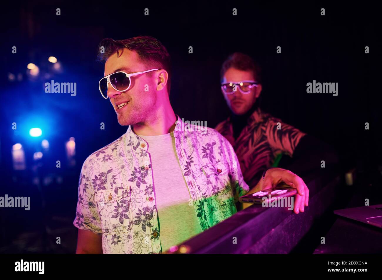 Young guy in elegant clothes and sunglasses sniffing drug in night club ...