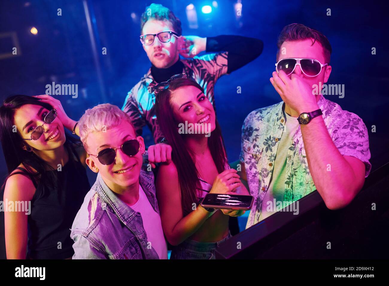 Young people sniffing drug in nightclub with colorful laser lights ...