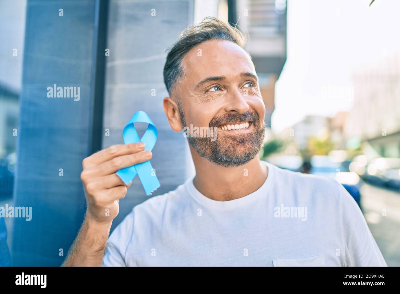 Middle age handsome man smiling happy holding blue prostate cancer ...