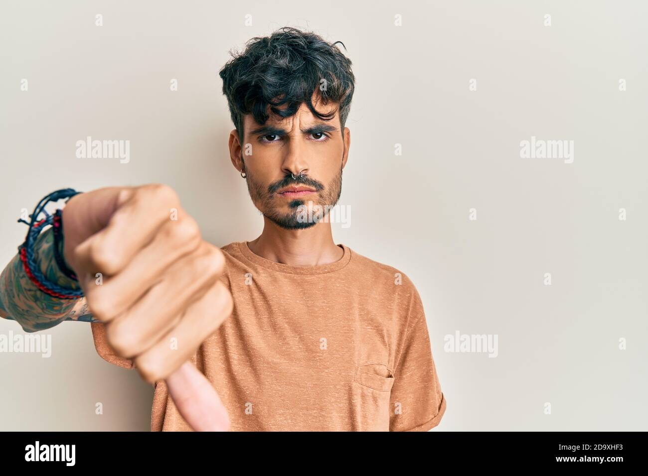 Young hispanic man wearing casual clothes looking unhappy and angry ...