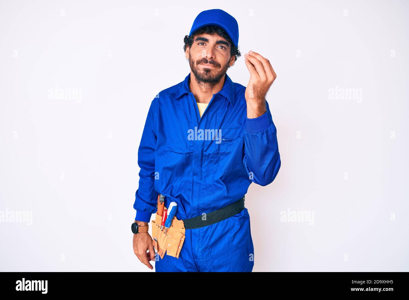 Handsome young man with curly hair and bear weaing handyman uniform ...