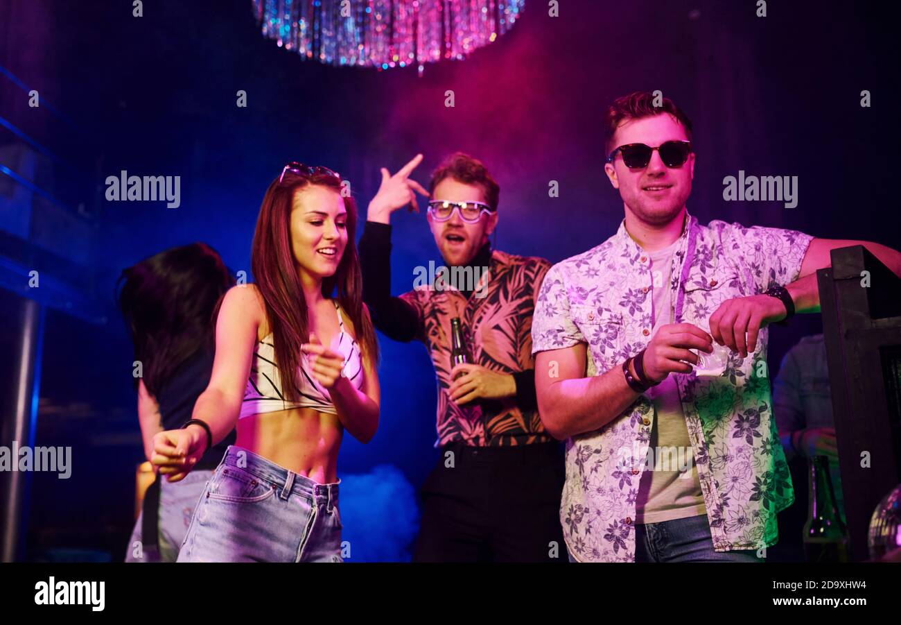 Young people is having fun in night club with colorful laser lights ...