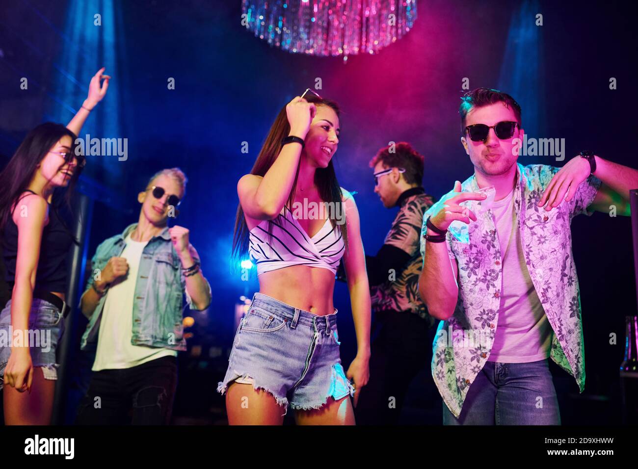 Young people is having fun in night club with colorful laser lights ...