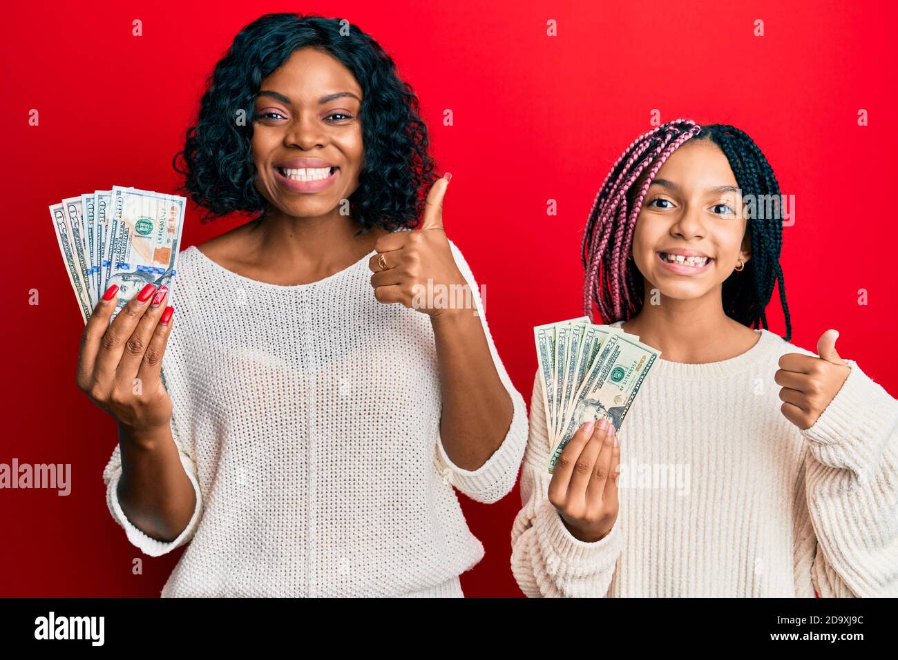 Beautiful african american mother and daughter holding dollars smiling ...