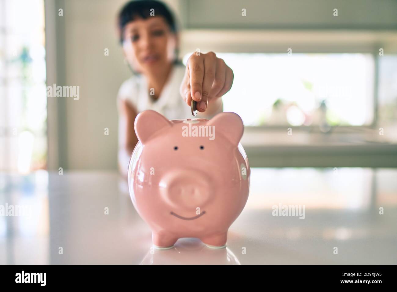 Young brunette woman smiling happy putting money savings inside of ...