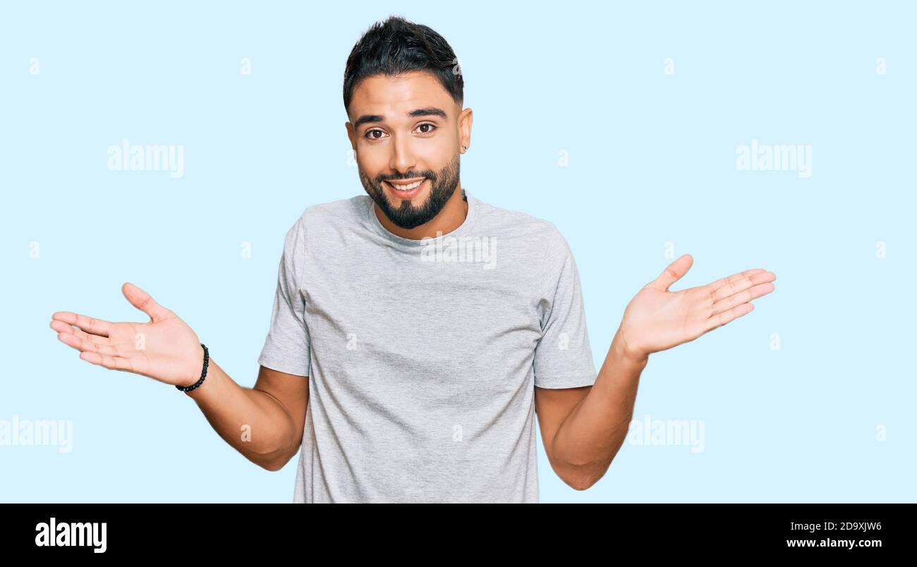 Young man with beard wearing casual grey tshirt clueless and confused ...