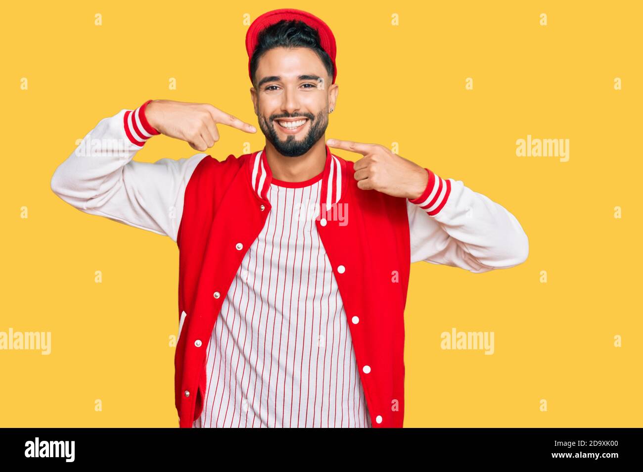 Young man with beard wearing baseball uniform smiling cheerful showing ...