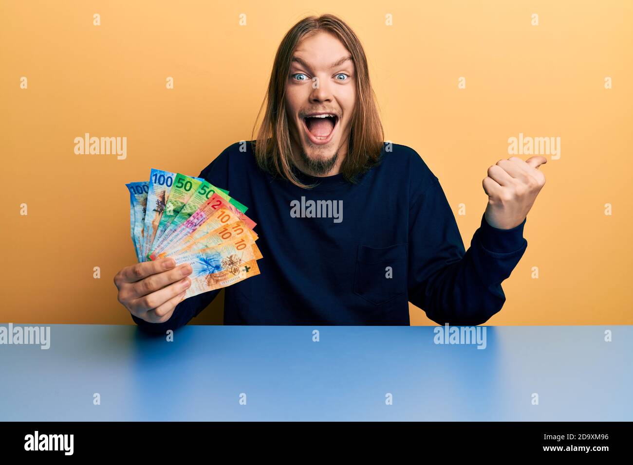 Handsome caucasian man with long hair holding swiss franc banknotes ...