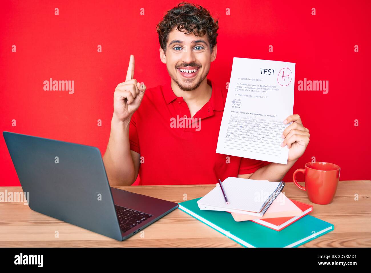 Young caucasian man with curly hair showing a passed exam sitting on ...