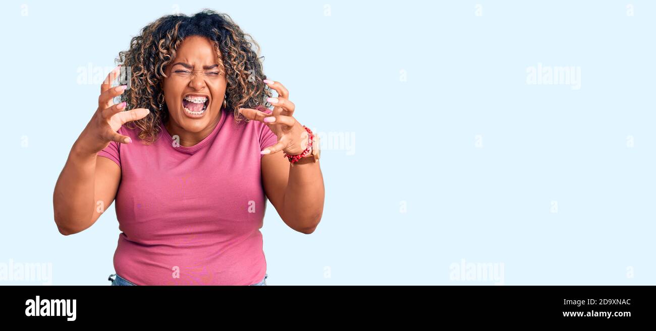 Young african american plus size woman wearing casual clothes shouting ...