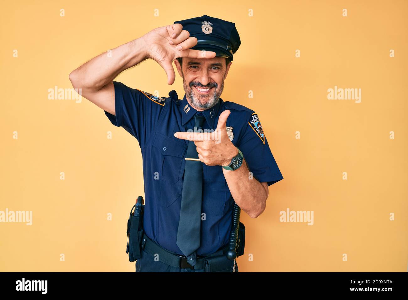 Middle age hispanic man wearing police uniform smiling making frame ...