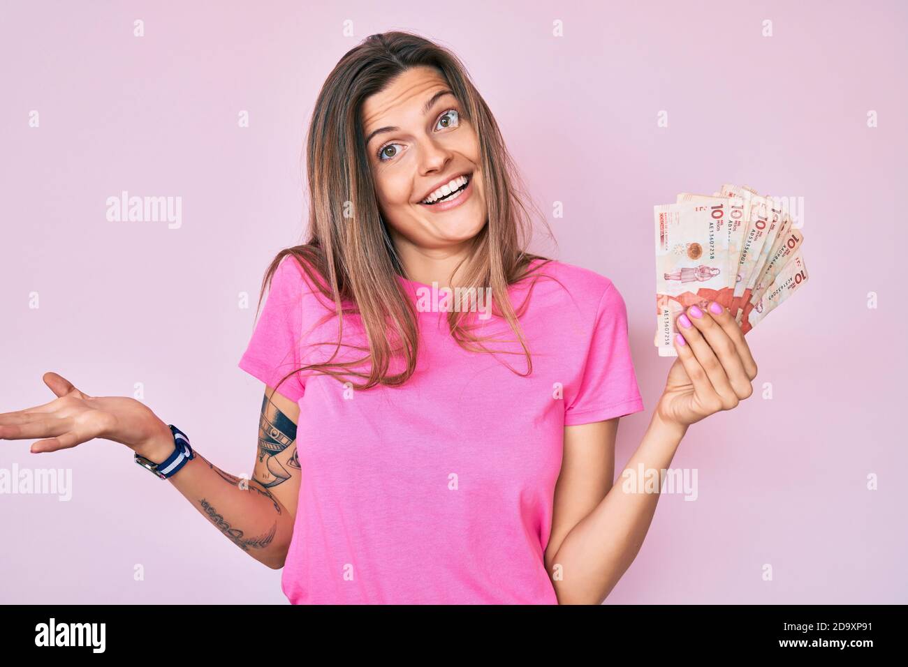 Beautiful caucasian woman holding colombian pesos celebrating ...