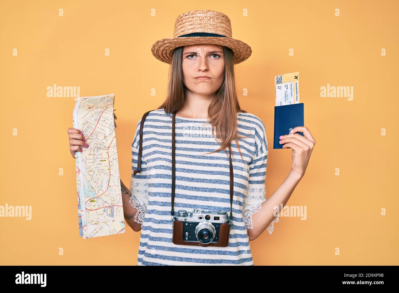 Beautiful caucasian tourist woman holding city map and passport skeptic ...