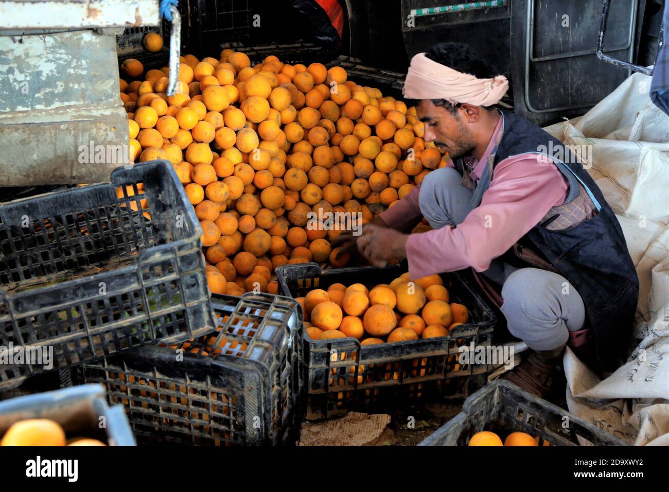 Sanaa, Yemen. 8th Nov, 2020. A vendor fills baskets with oranges for ...