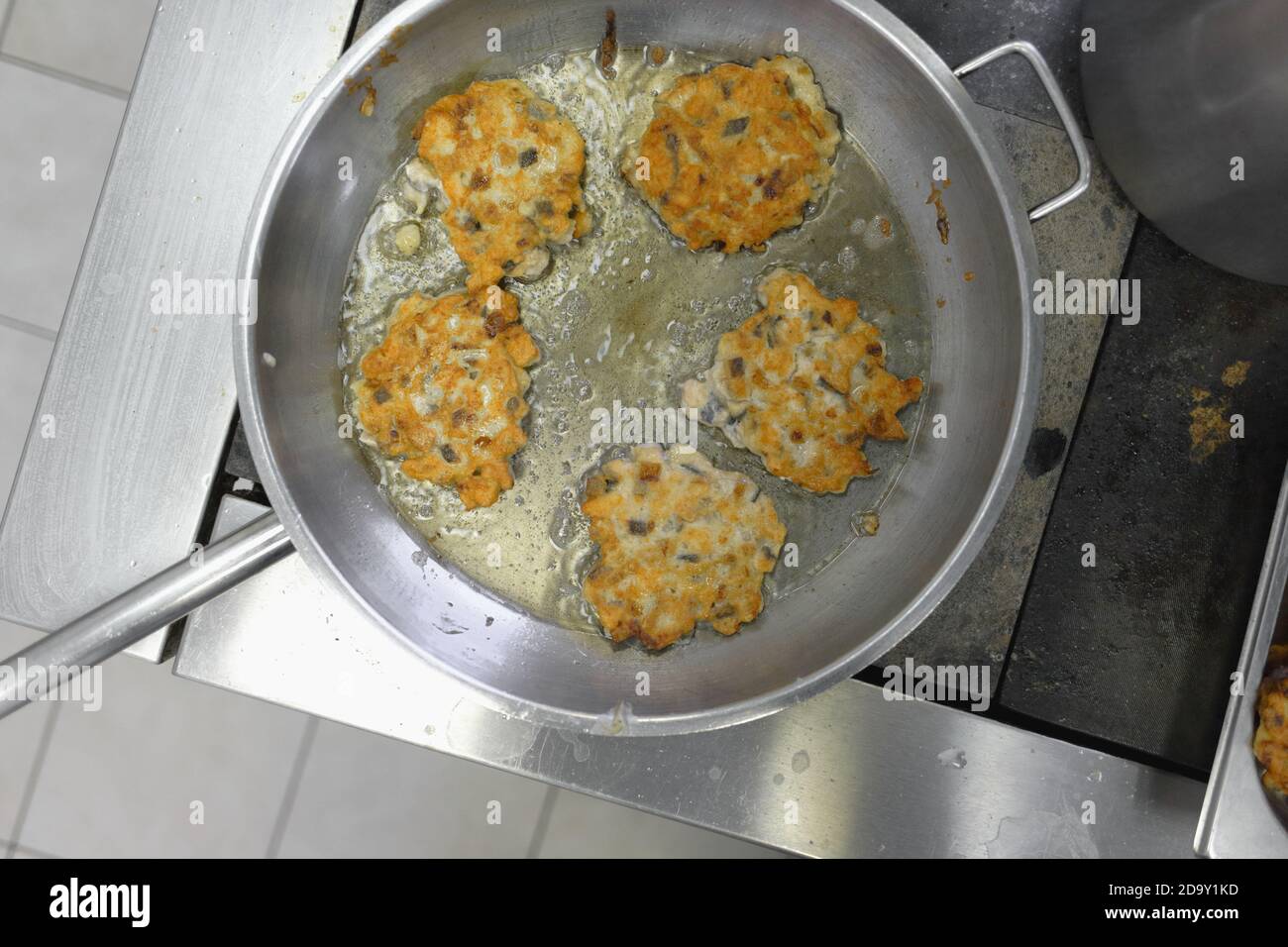 Cooking meat in batter on the stove in a fast food canteen. Fat and ...
