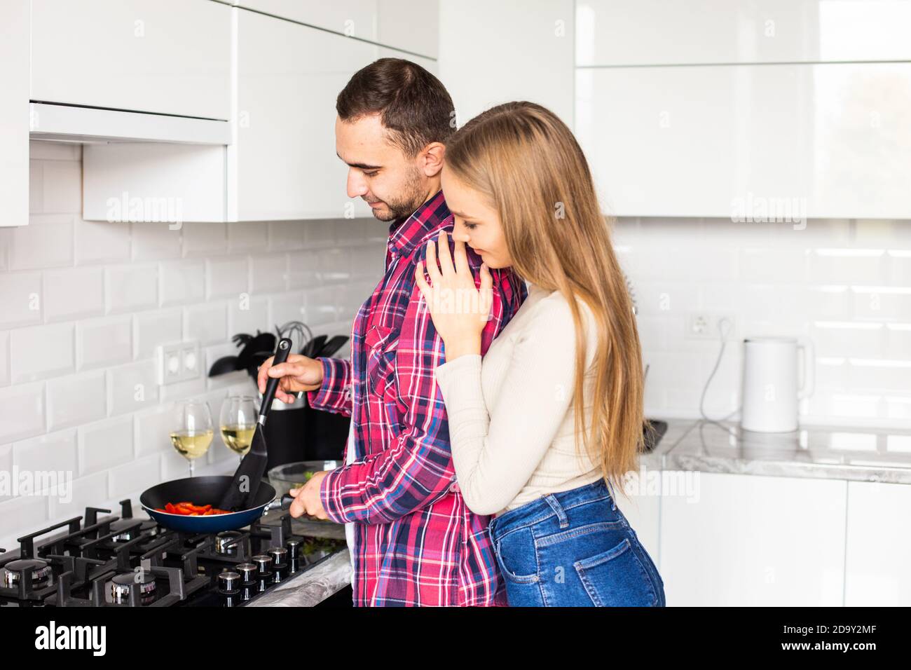 Young man cooking with girlfriend and adding spice to the sauce. Guy ...