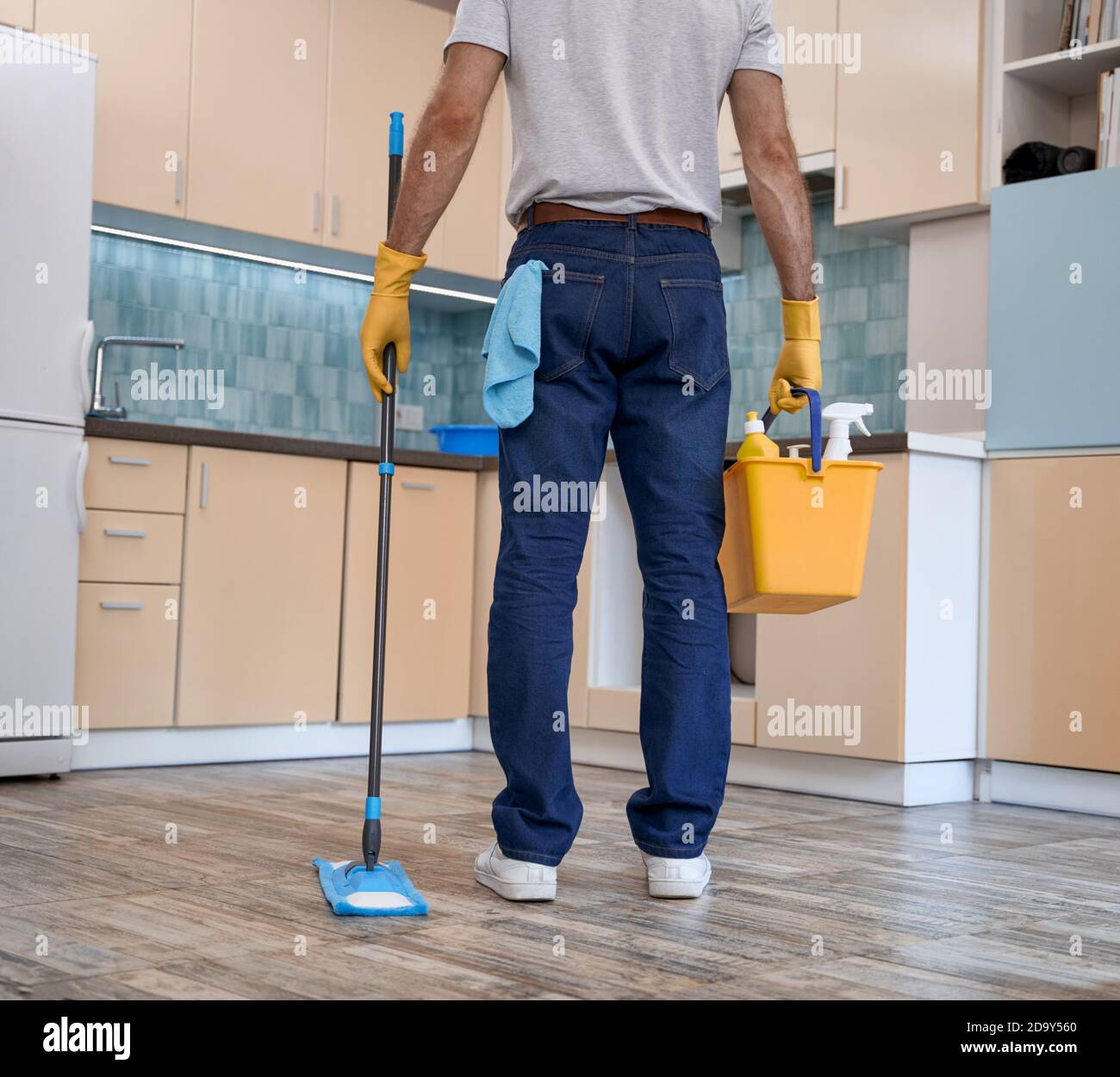 Man holding mop and bucket with cleaning stuff Stock Photo - Alamy