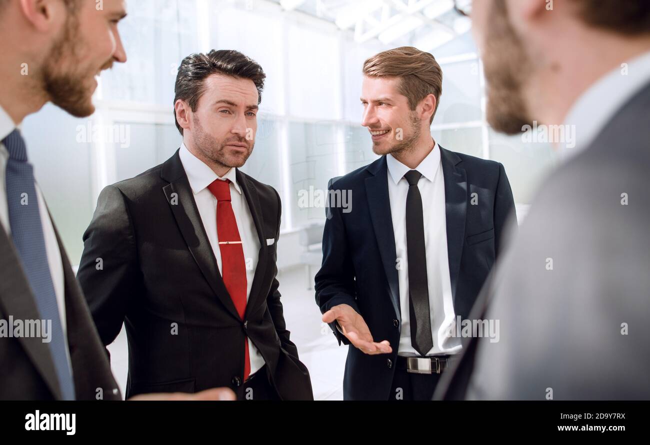 Manager and employees of the company talking standing in the office ...