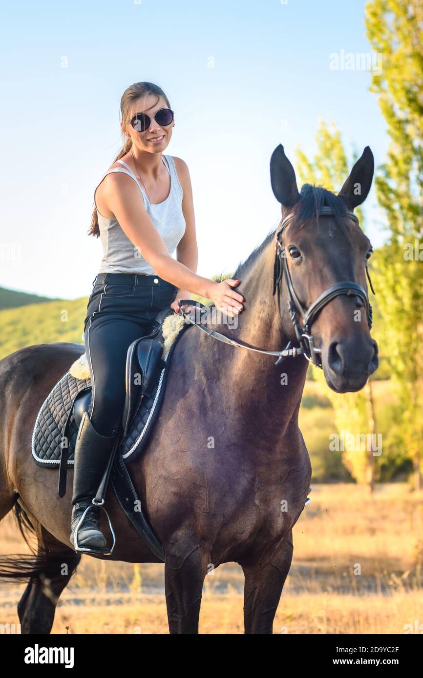Beautiful slender pretty girl sitting on a horse, close-up Stock Photo ...