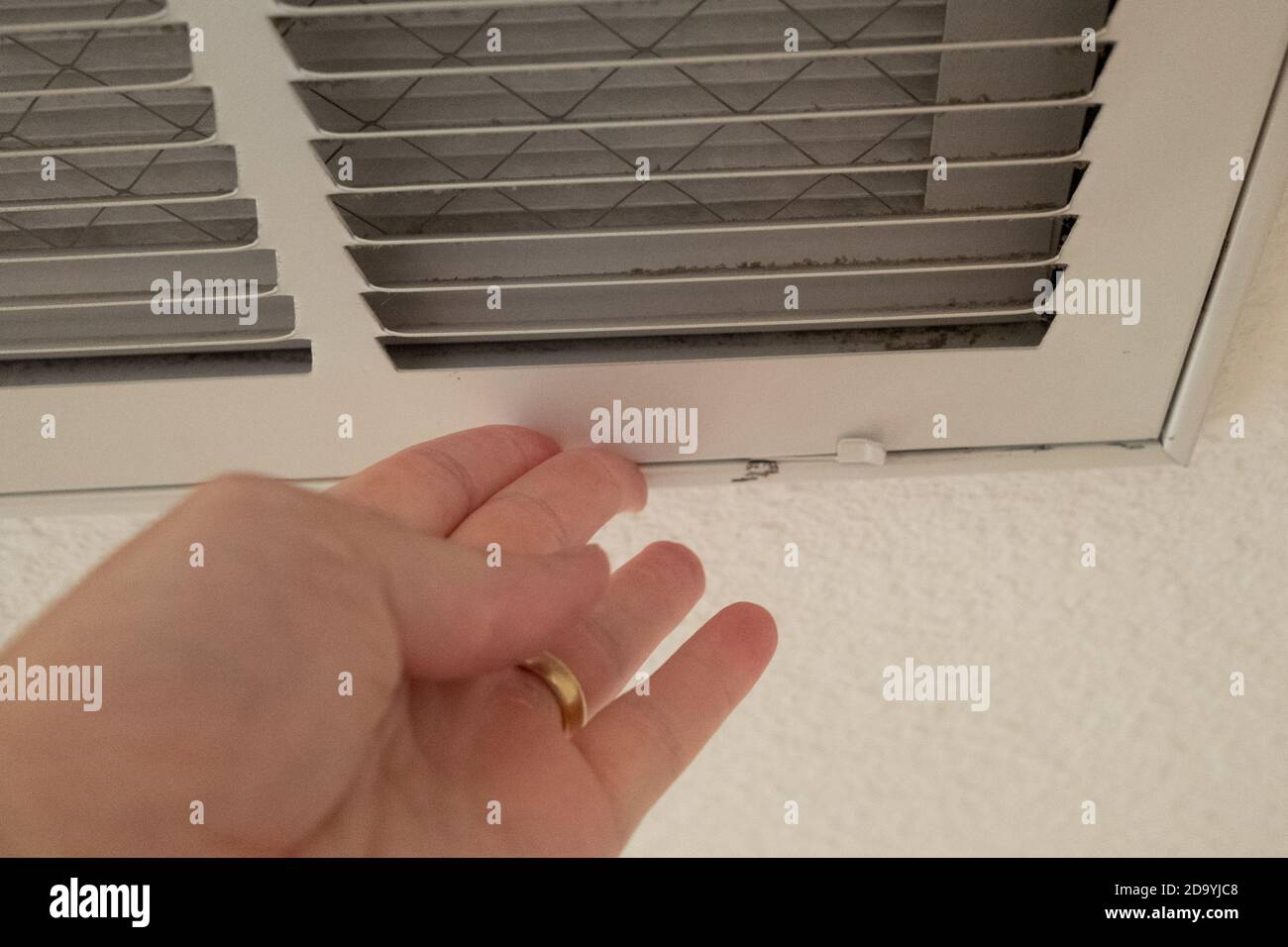 Hand of a man opening filter holder on HVAC return air duct, San Ramon ...