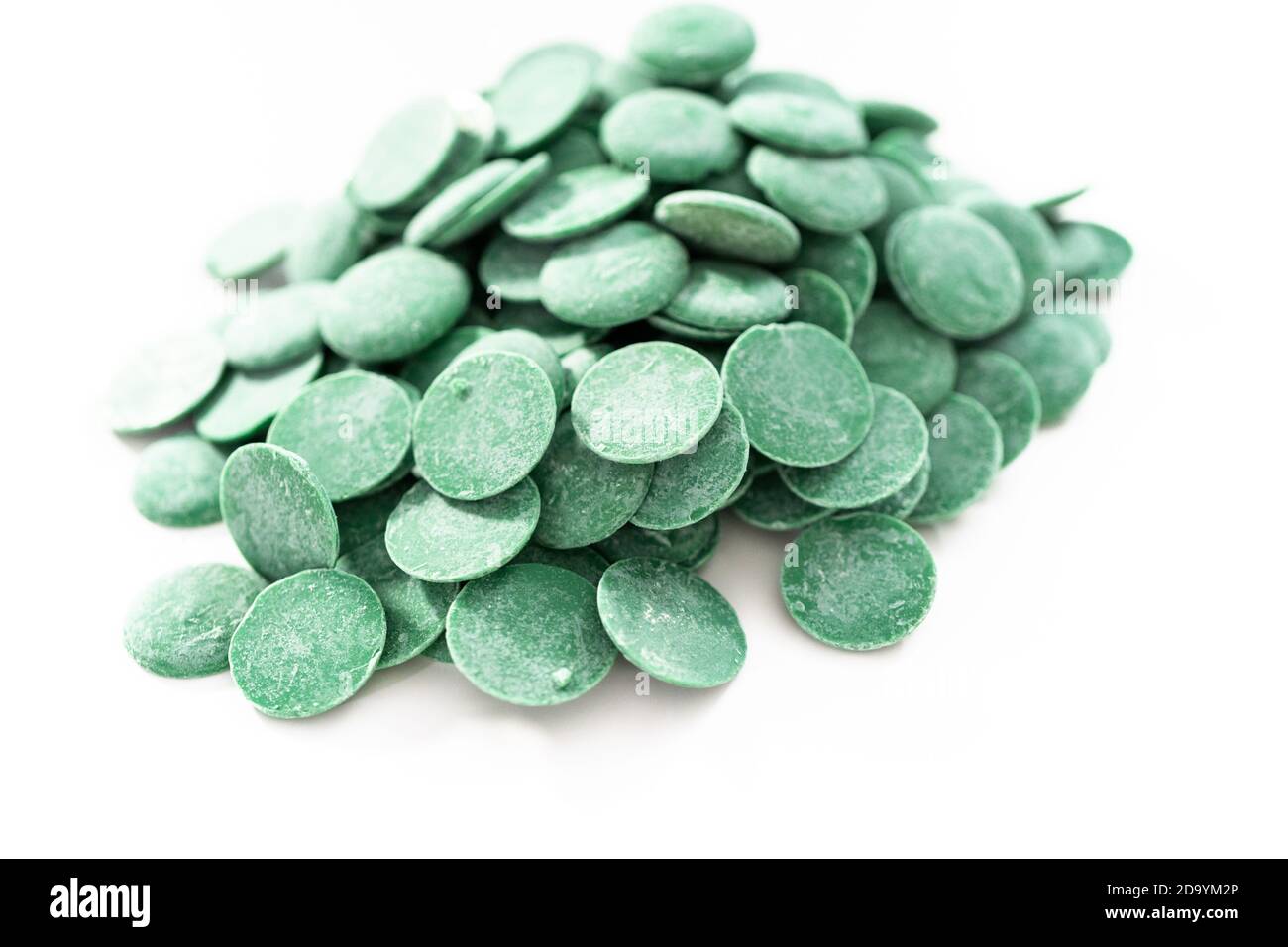 Green round chocolate chips for melting chocolate shapes on a white ...