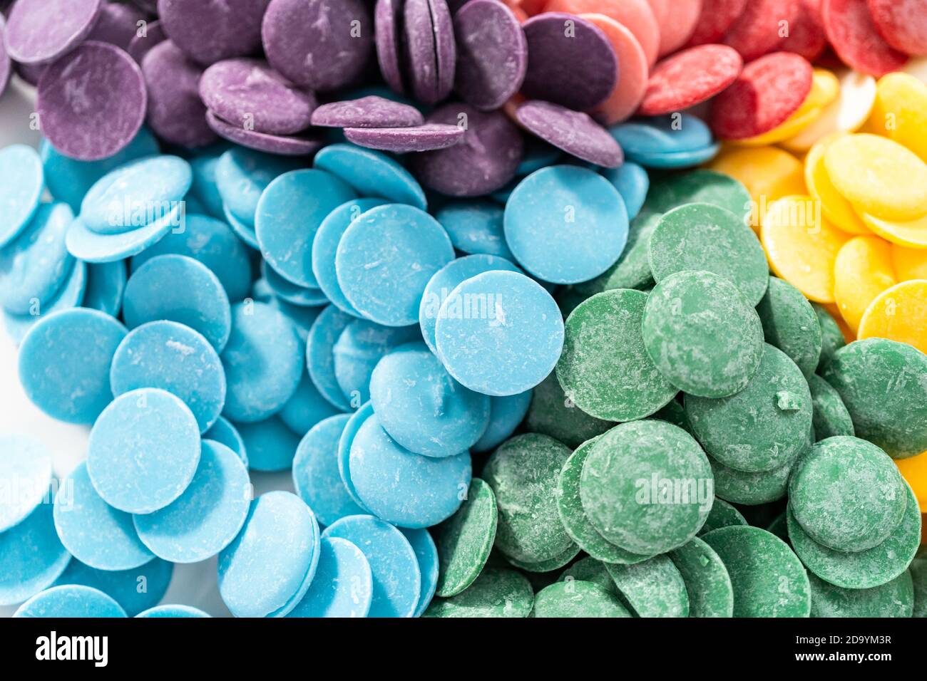 Rainbow colors of round chocolate chips for melting chocolate shapes on ...