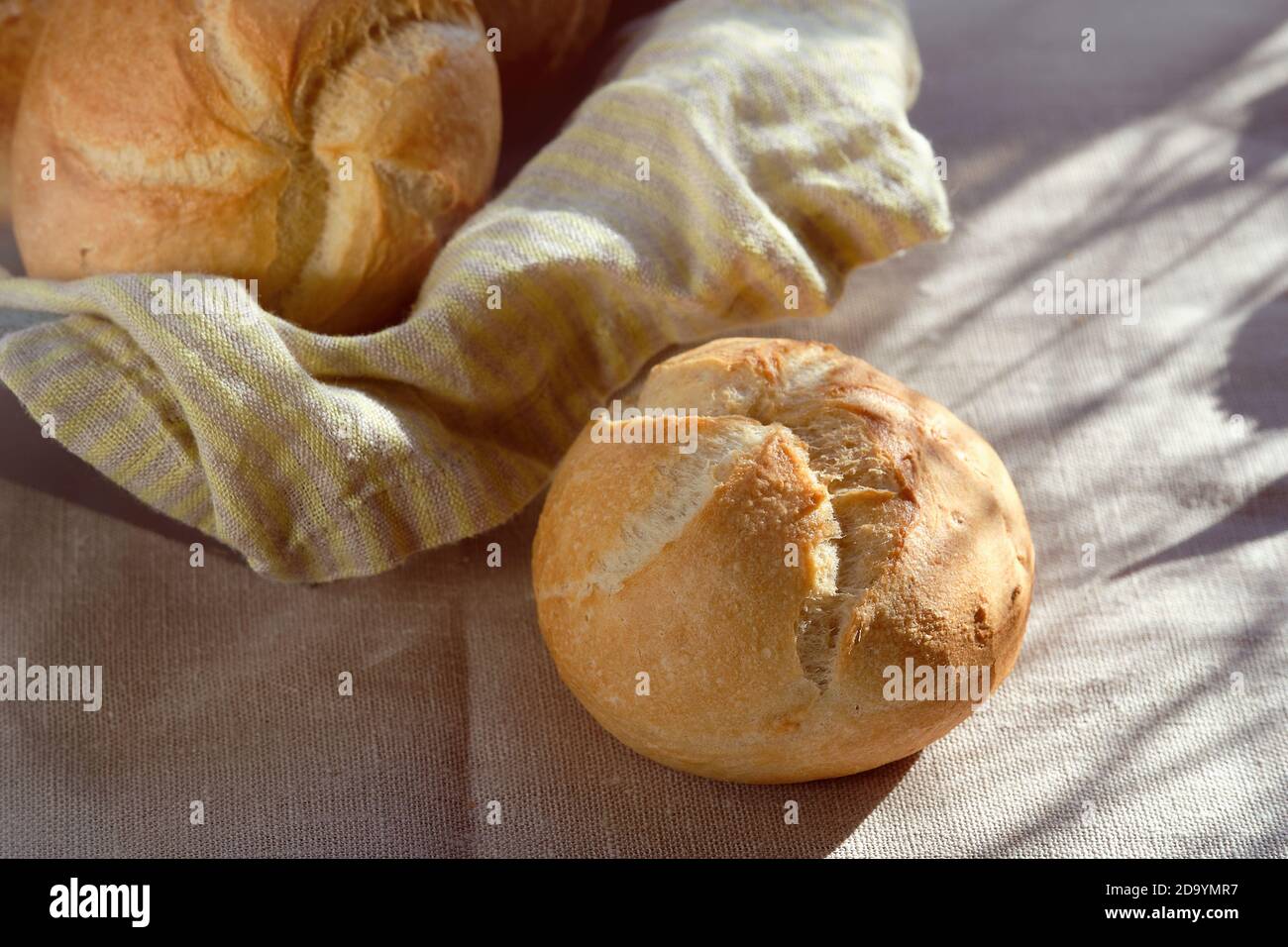 Close-up on rusty round bun and busket of Kaiser or Vienna rolls on ...