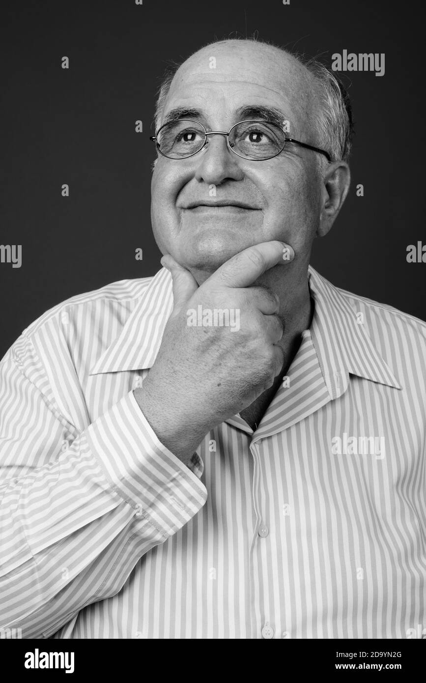 Overweight senior man wearing eyeglasses against brown background Stock ...