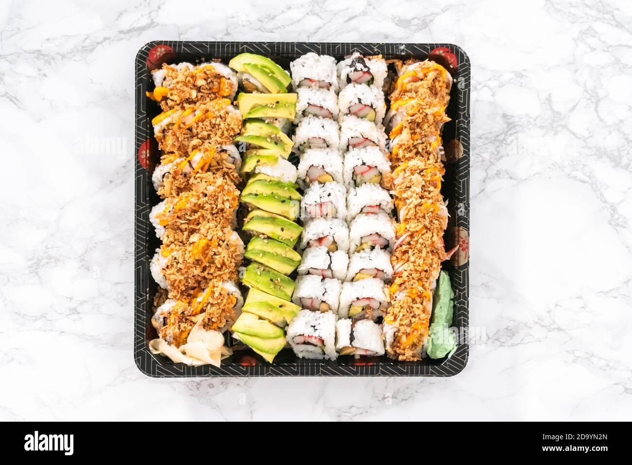 Flat lay. Pre-packaged variety of sushi and sushi rolls in a plastic ...