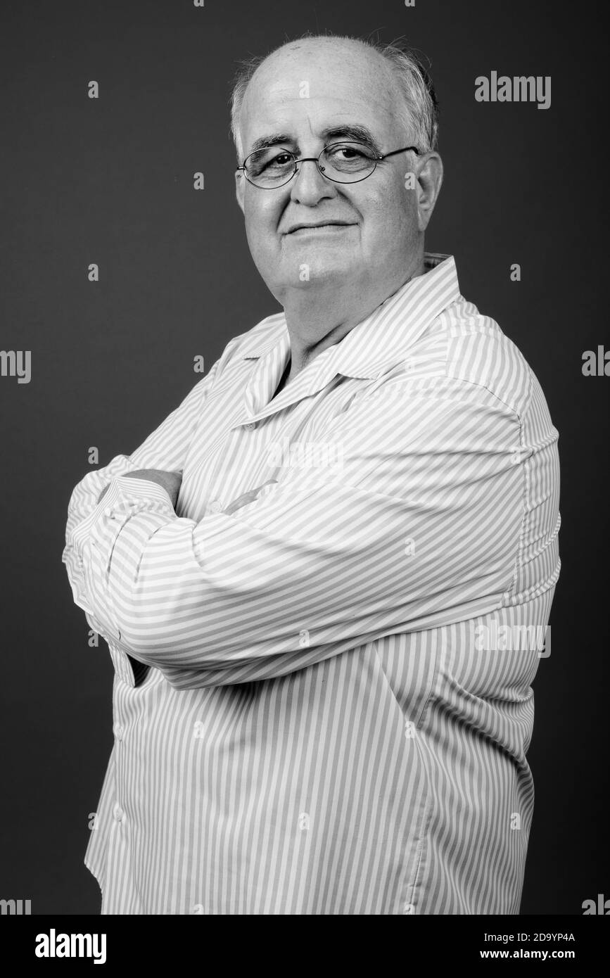 Overweight senior man wearing eyeglasses against brown background Stock ...