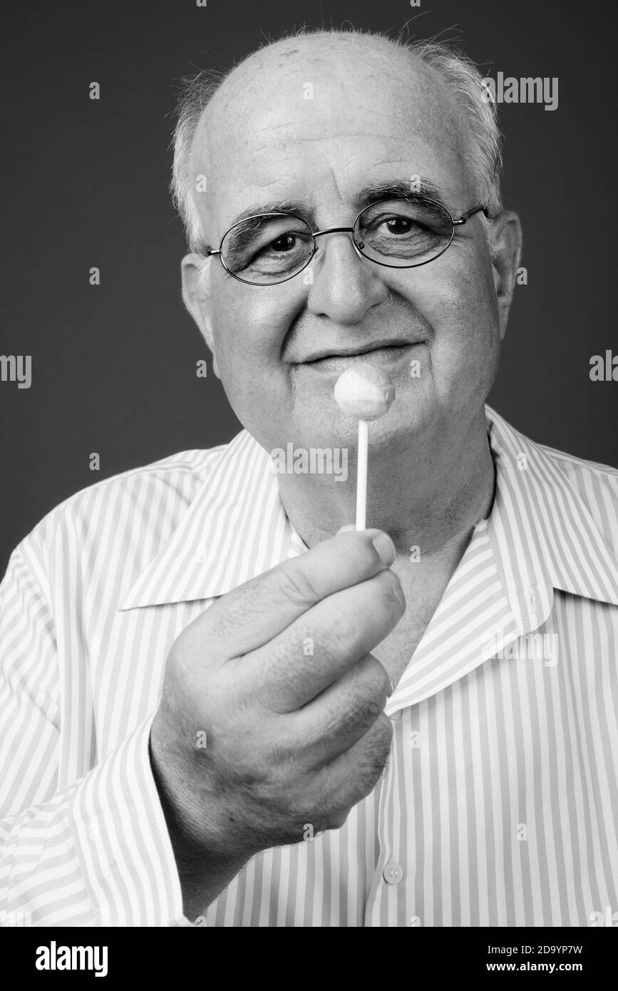 Overweight senior man wearing eyeglasses against brown background Stock ...