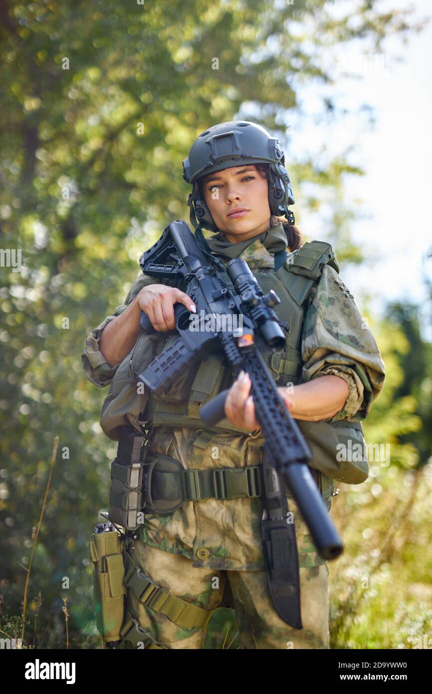 strong brave female army soldier with rifle machine gun standing in the ...