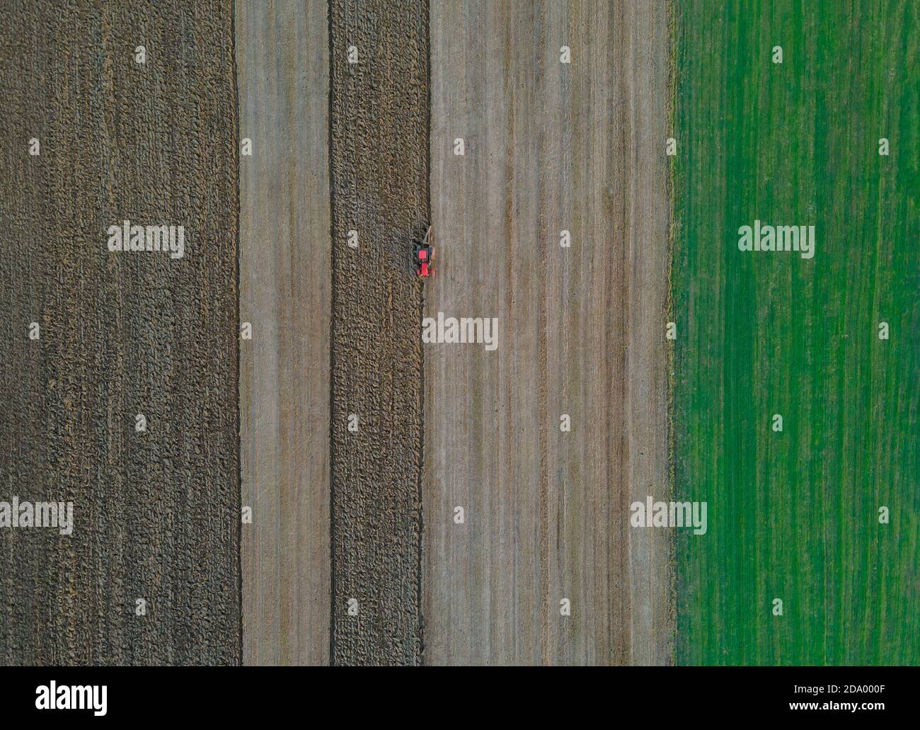 Aerial view on of agricultural field modern red tractor plowing land ...