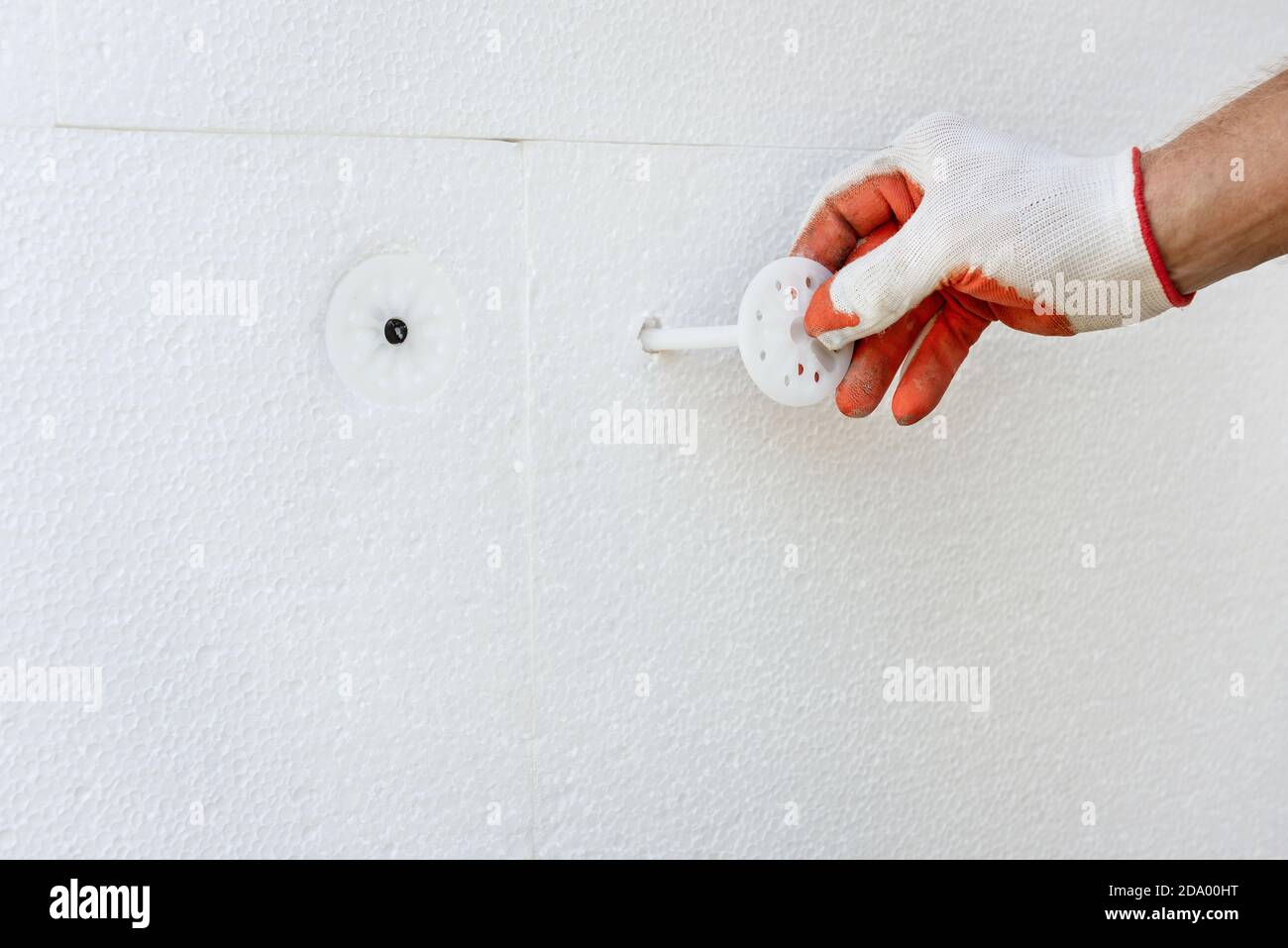 Insulation of the house with polyfoam. The worker is fixing a ...