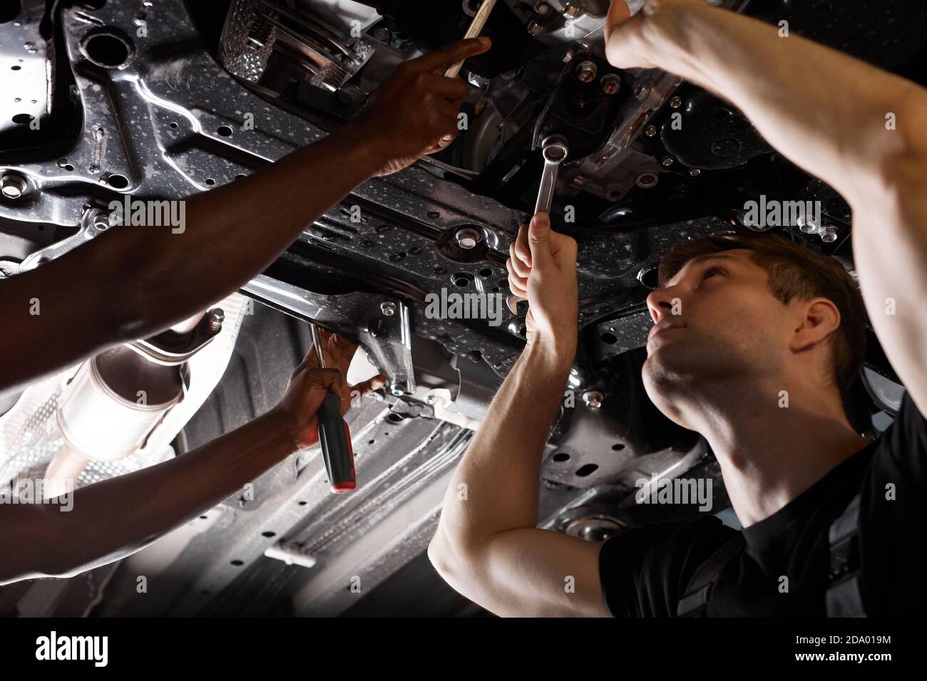 two friendly professional auto mechanic during work, they are ...
