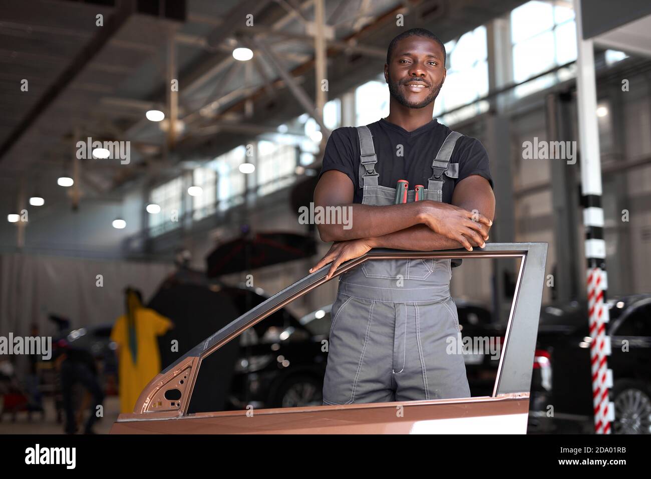 portrait of positive afro american auto mechanic in uniform posing ...