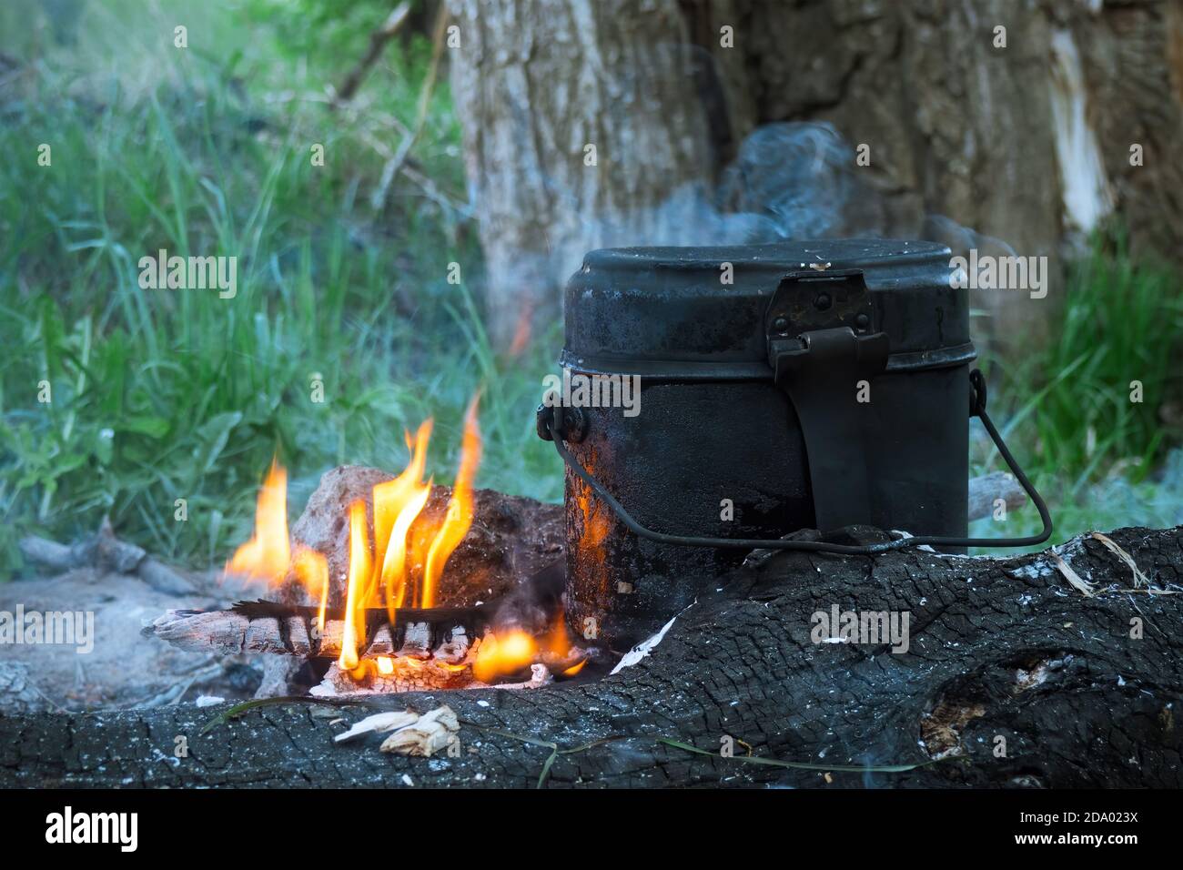 Hiking smoked pot on the coals, old black military bowler in campfire ...