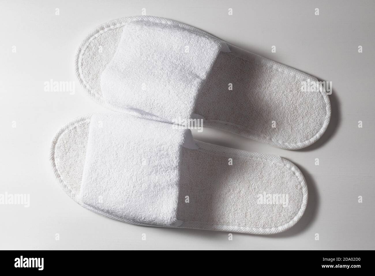 Top view of white slippers on a white wooden background Stock Photo - Alamy