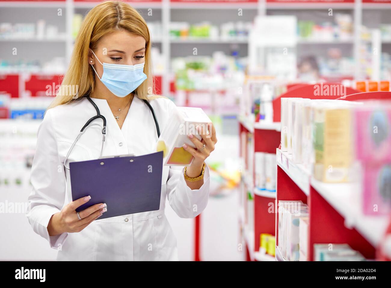 female pharmacist fulfilling a prescription holding drugs in hand, she ...