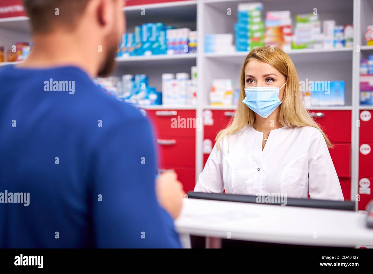 professional female pharmacist helping male customer choosing ...