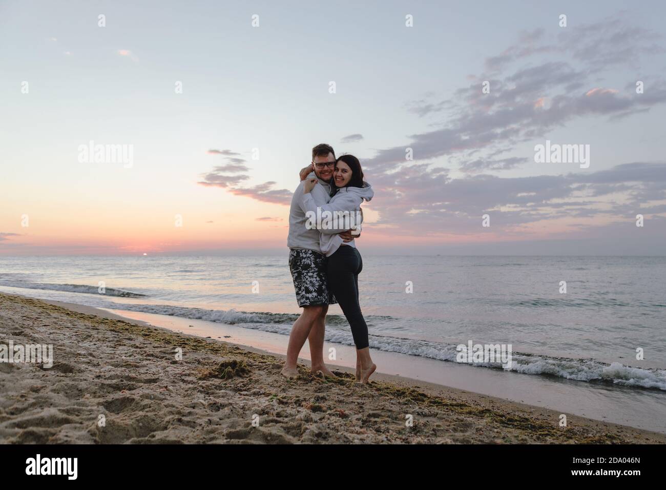 couple hugging look at sunset above sea Stock Photo - Alamy