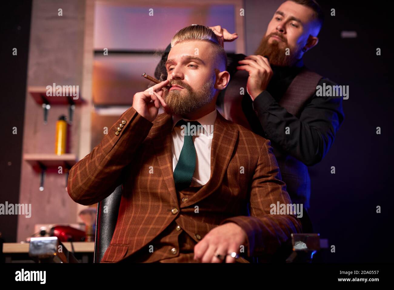 stylish male enjoy haircut at the hairdresser, he is smoking during ...