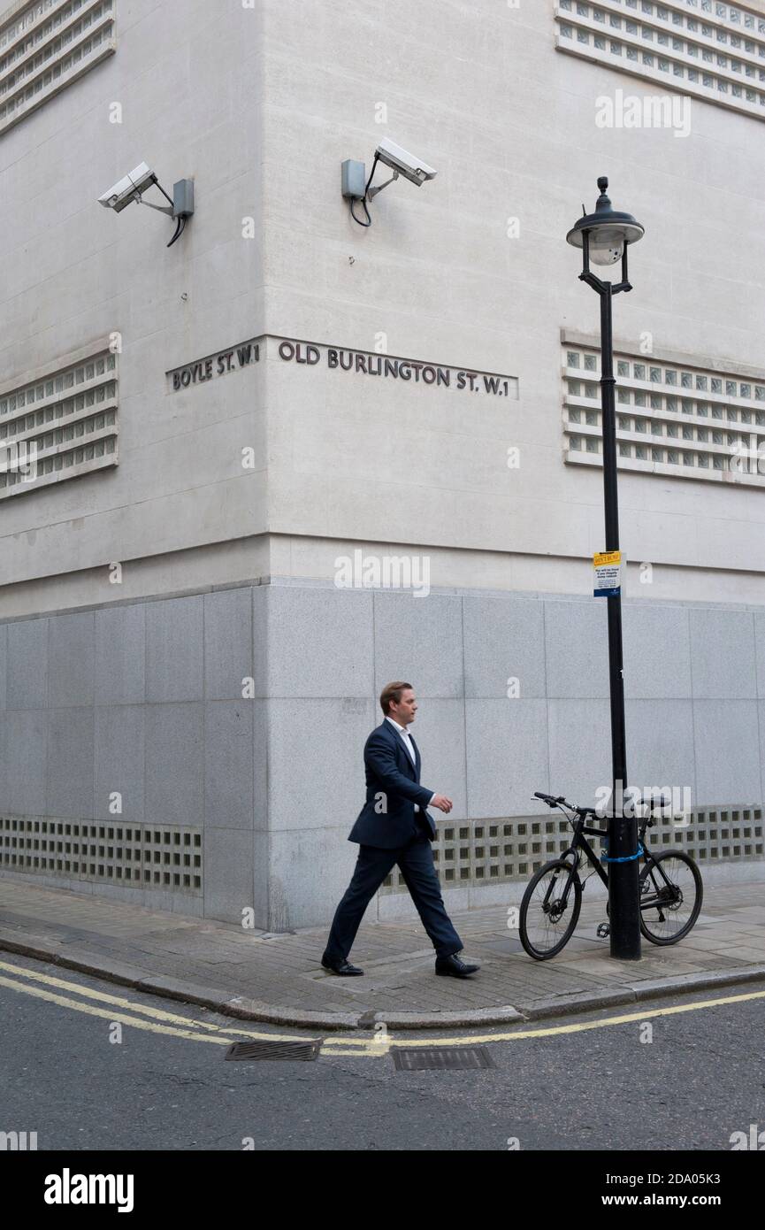 A man walking past 2 cctv surveillance cameras, Old Burlington Street ...