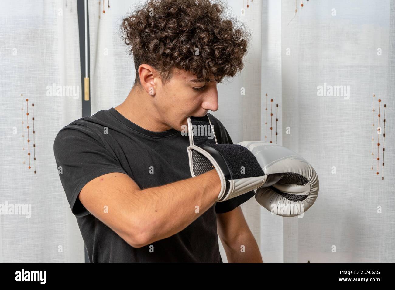 Attractive young man with curly hair wearing black t-shirt posing with ...