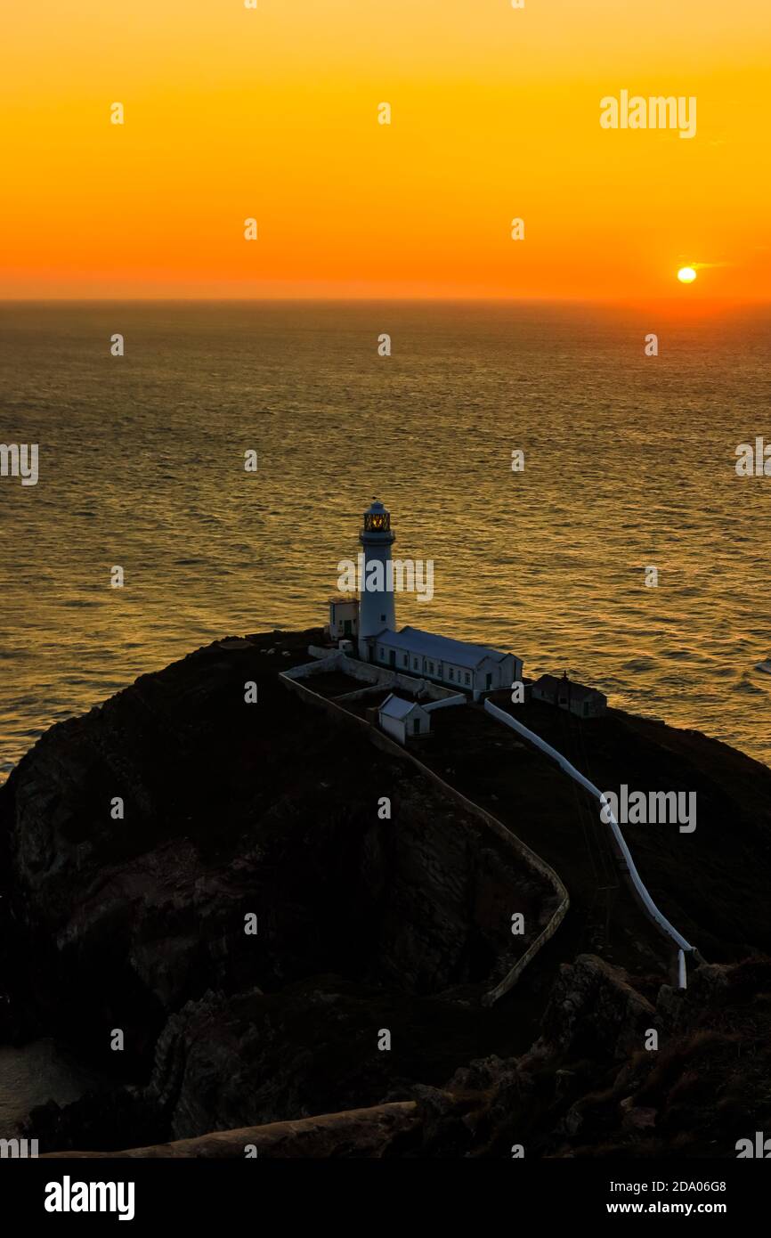 A lighthouse on cliffs with an ocean sunset (South Stack Lighthouse ...