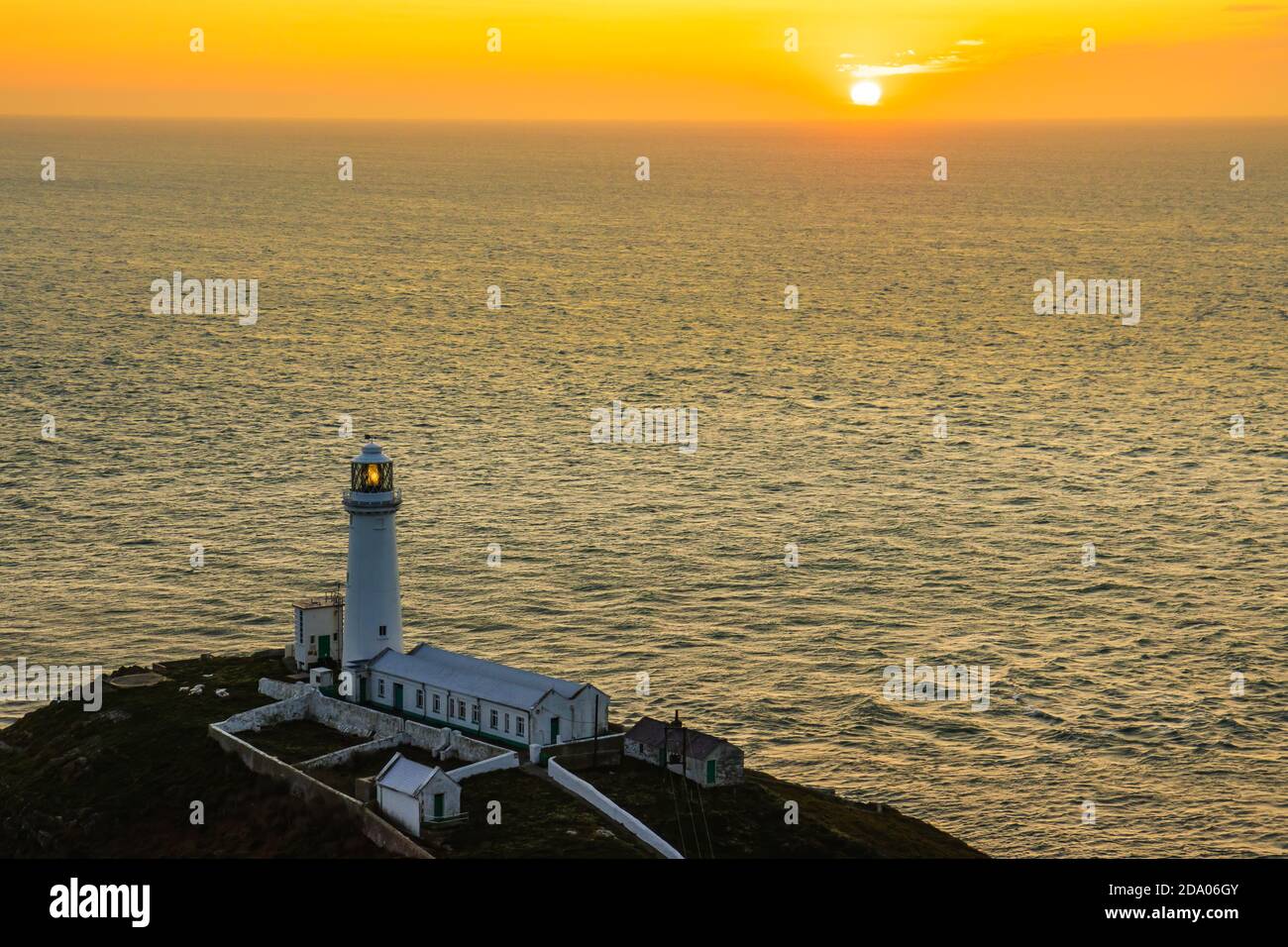 A lighthouse on cliffs with an ocean sunset (South Stack Lighthouse ...
