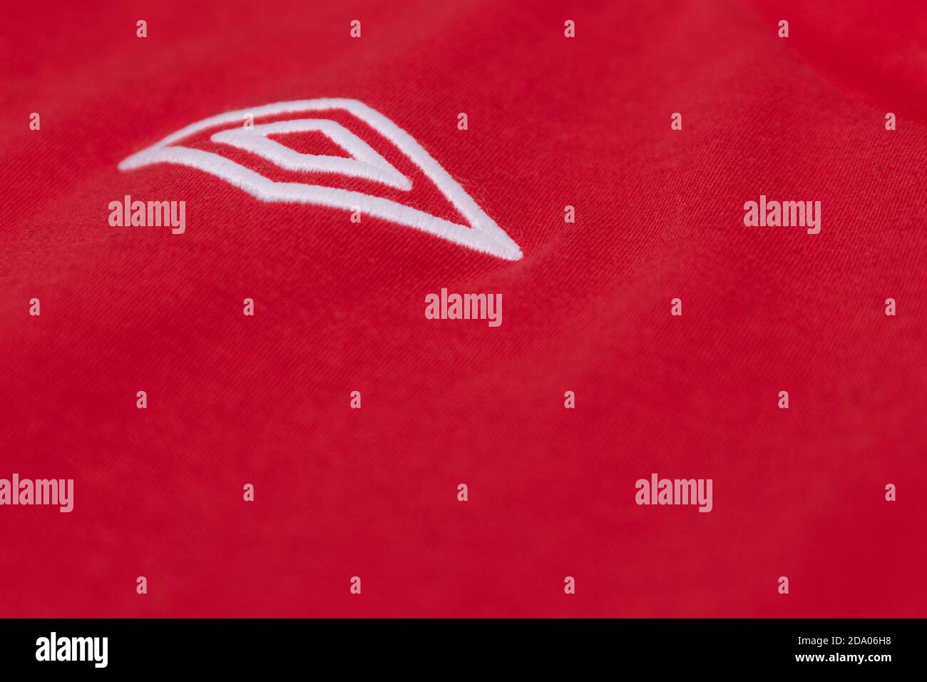 Silver White Embroidered Umbro logo on a red sports shirt Stock Photo ...