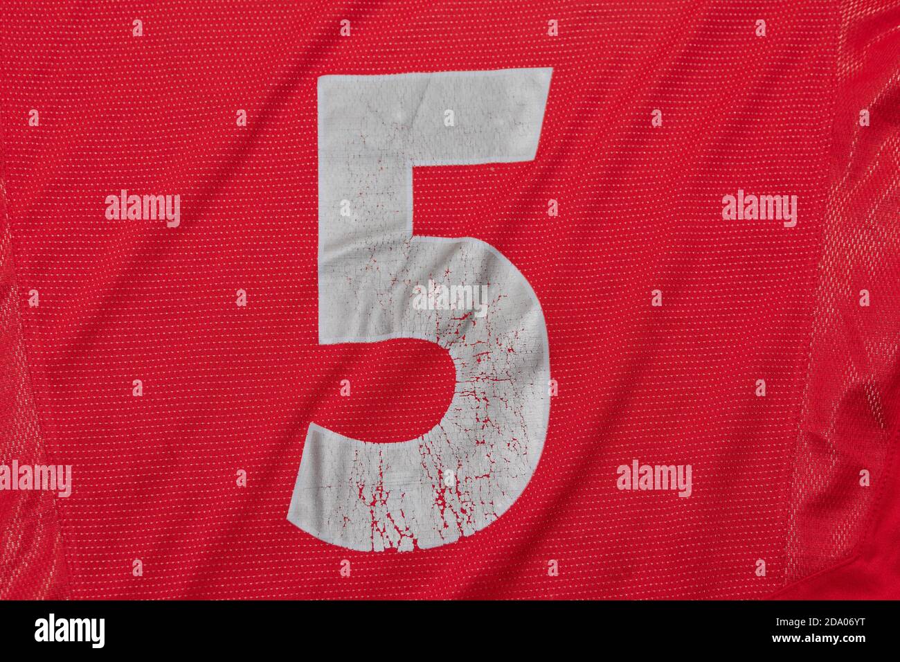 A worn number Five in white on the back of a red football shirt Stock ...
